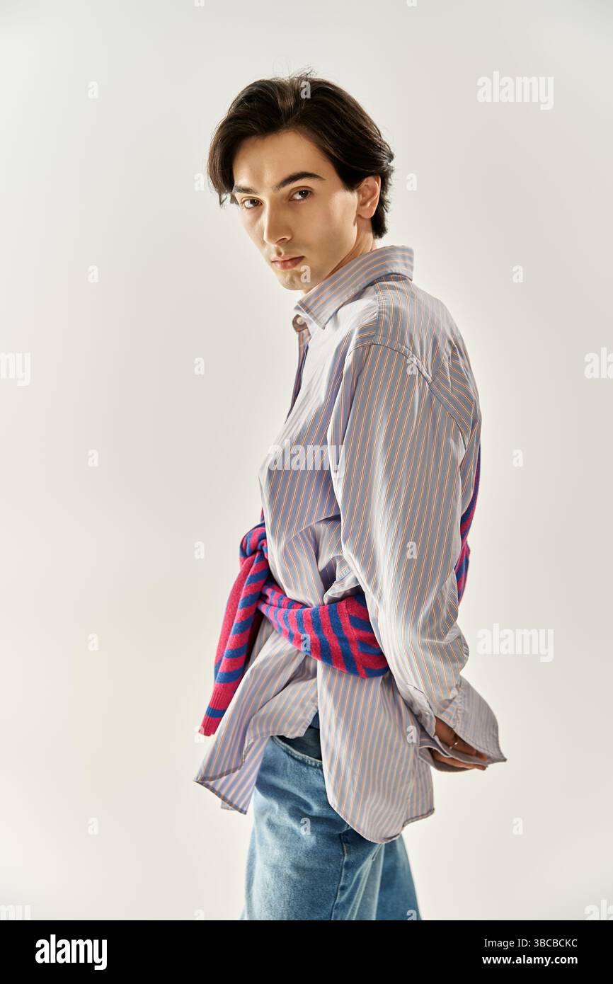 A young non-binary person showcases their stylish look in a bright ...