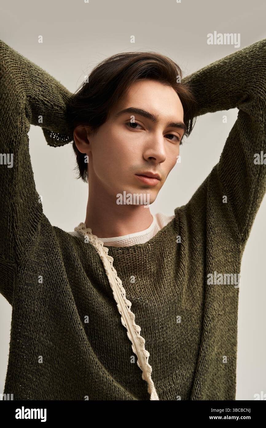 A young non-binary person confidently models a stylish knit sweater in ...