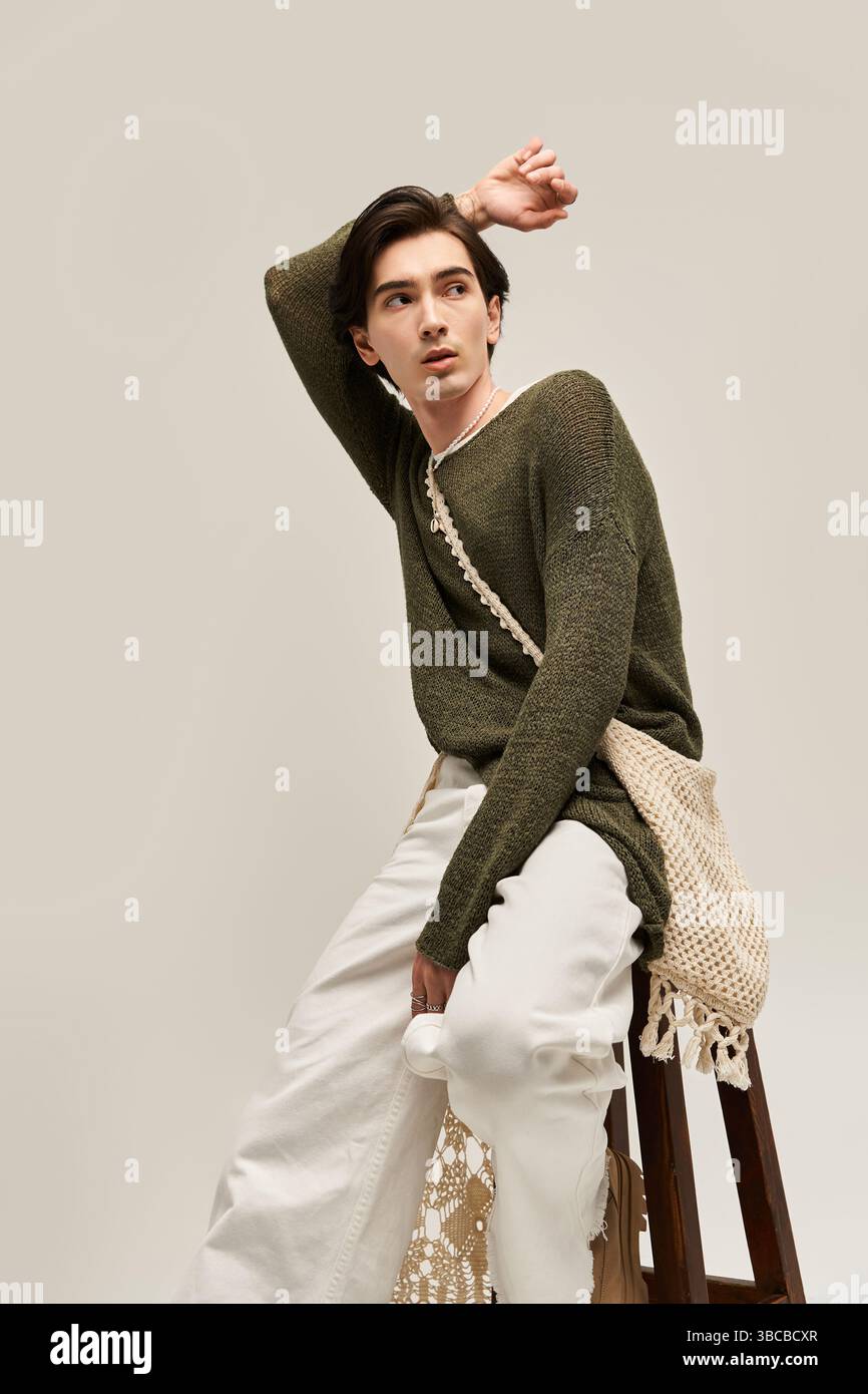 A young non binary individual poses stylishly on a stool, expressing ...