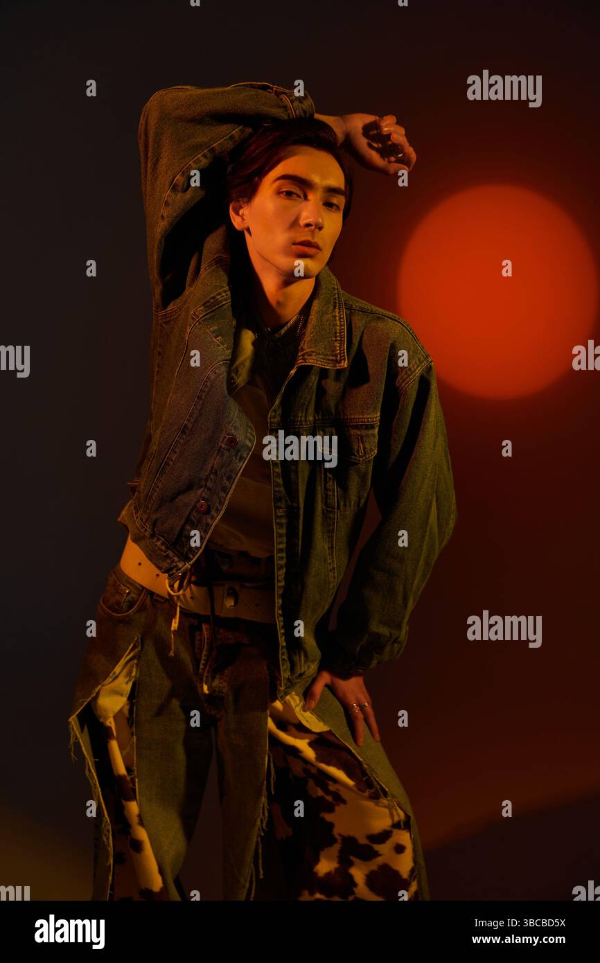 Stylish young non-binary individual poses confidently against a vibrant ...