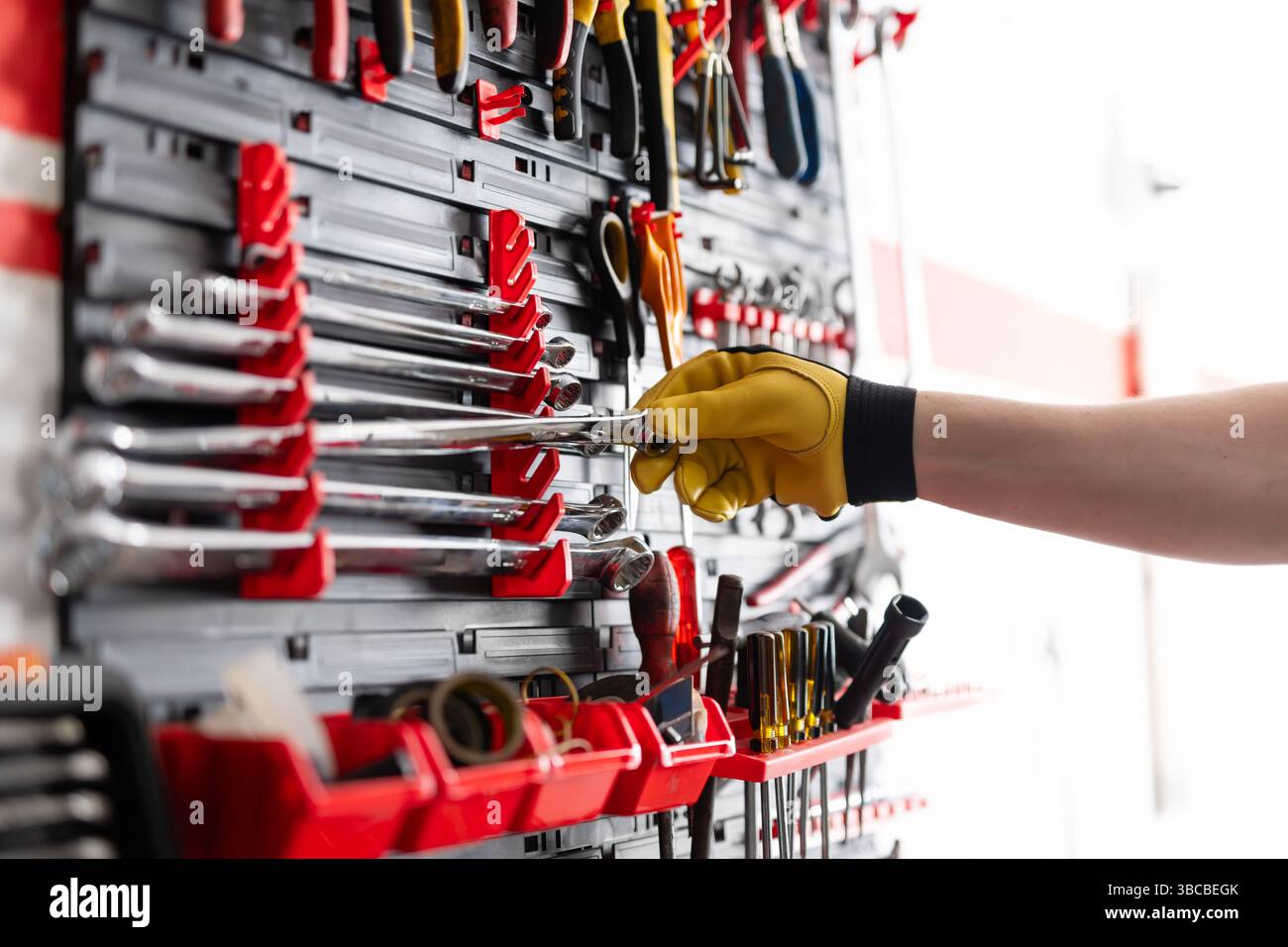 Mechanic Choosing A Wrench From A Garage Wall-Mounted Tool Organizer ...