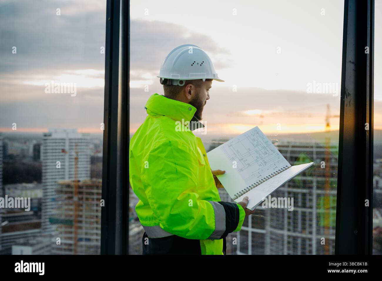Engineer overseeing city construction project, reading documentation ...