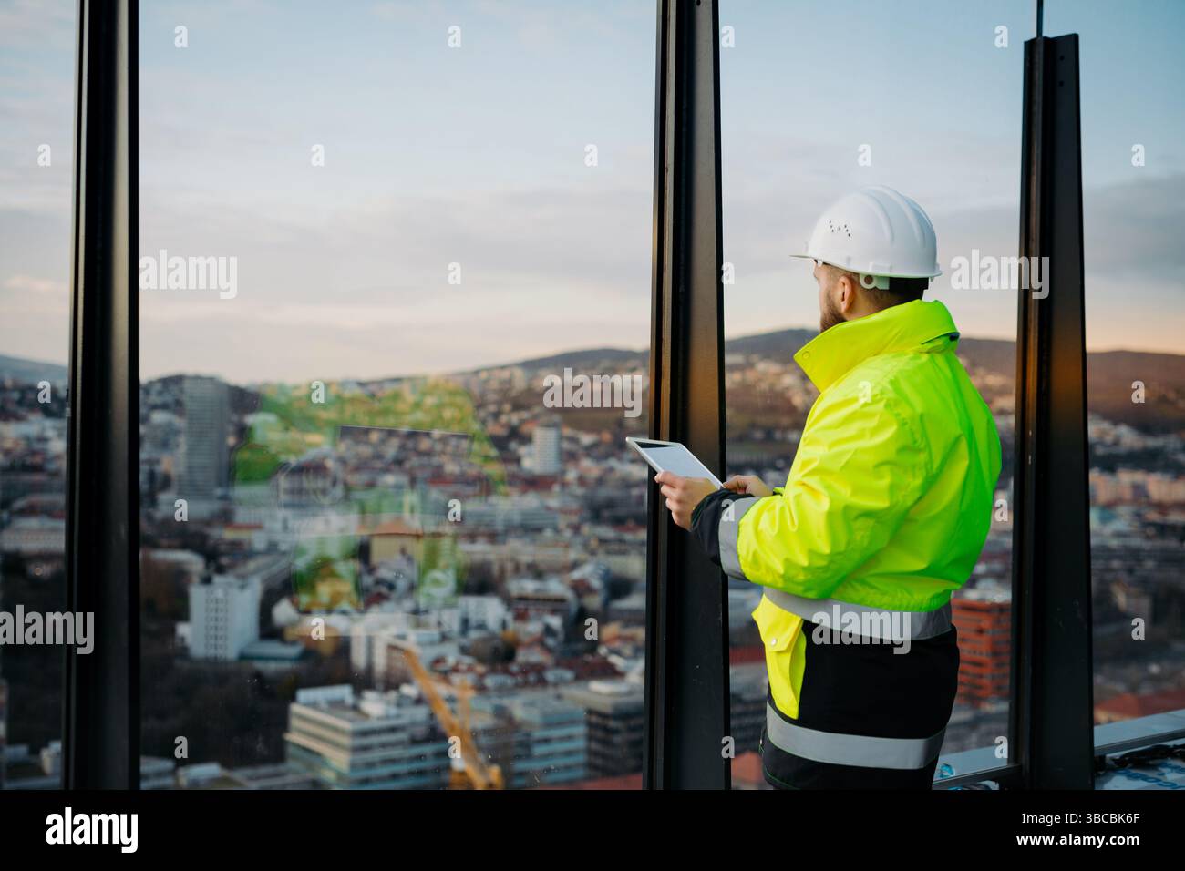 Engineer overseeing city construction project, reading documentation ...
