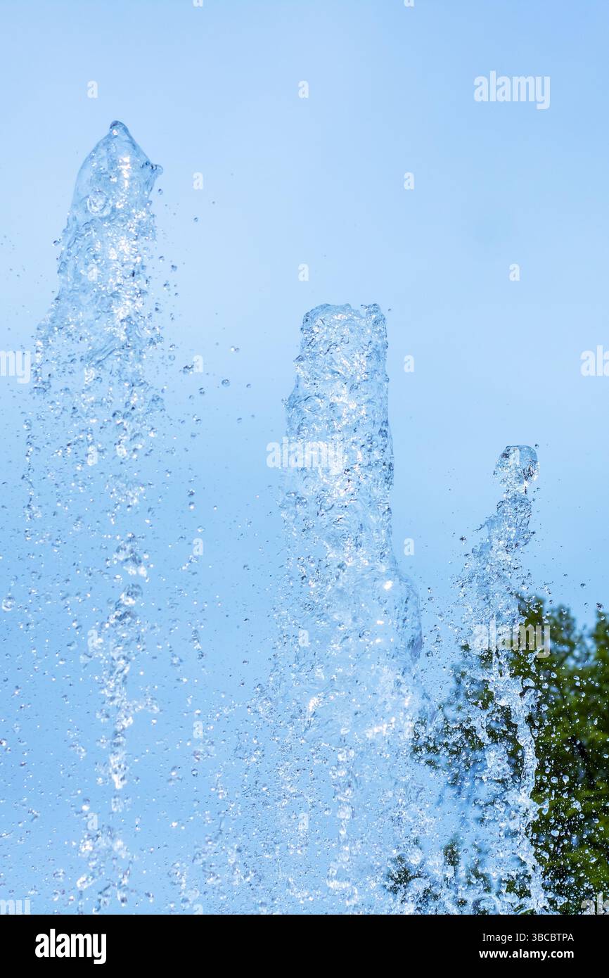 A beautiful fountain stands elegantly, with a bright blue sky serving ...