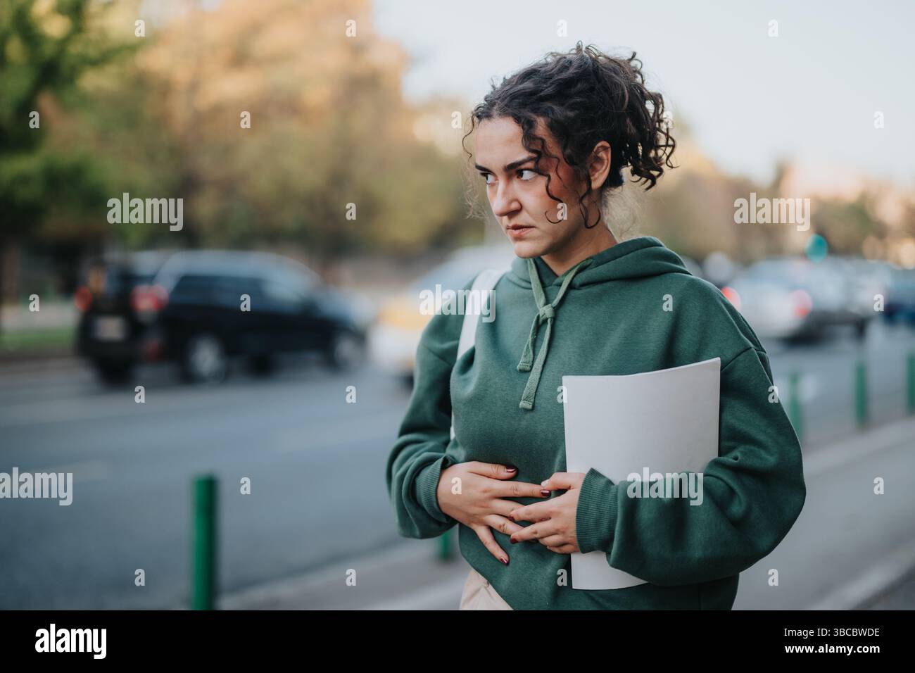 Woman outdoors holding documents with a serious and focused facial ...
