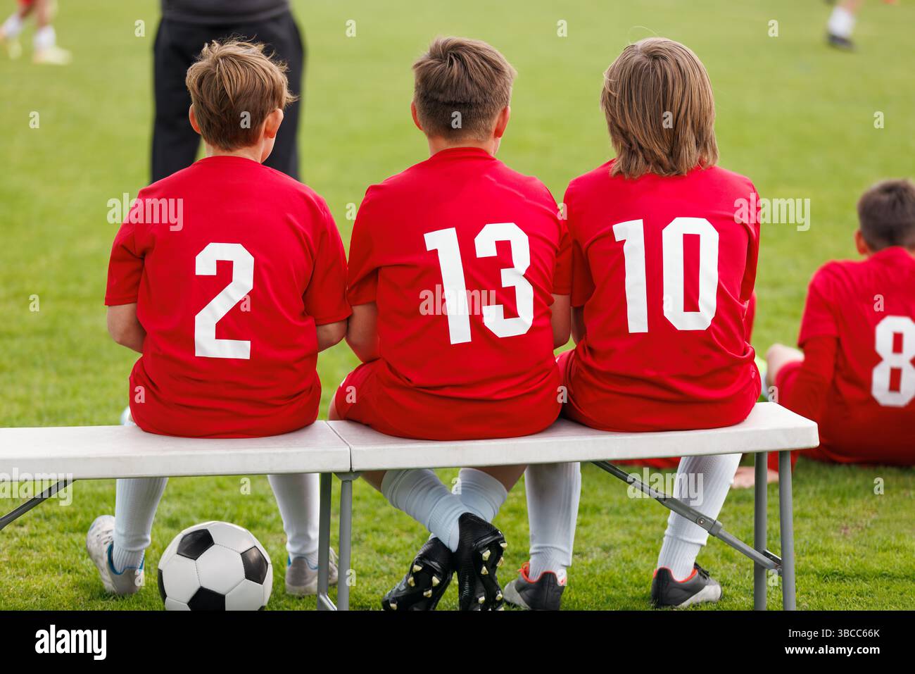 Young Soccer Players Wearing Jersey Numbers 2, 13, and 10 Sitting on ...