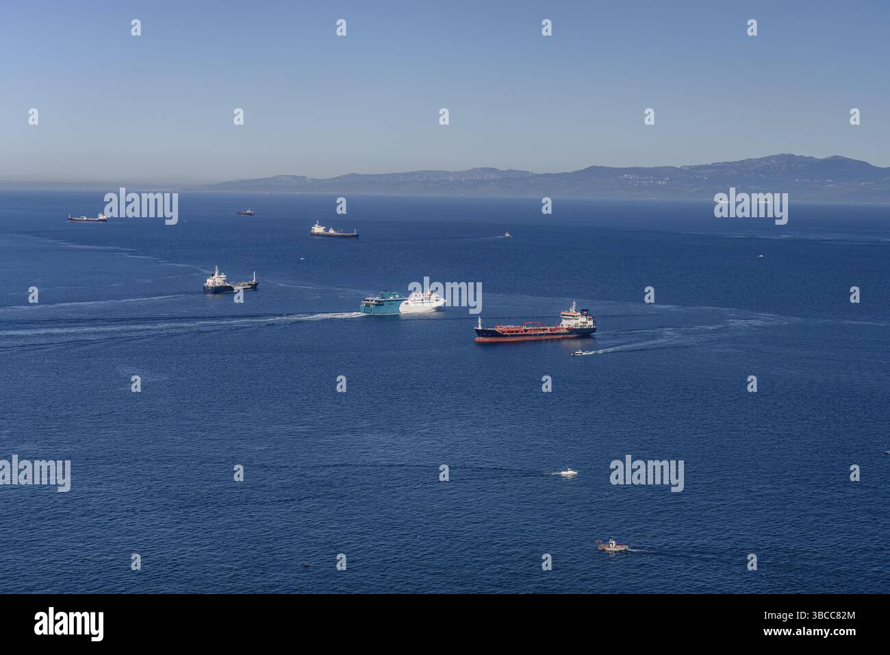 Multiple ships crossing the Strait of Gibraltar under clear blue skies ...