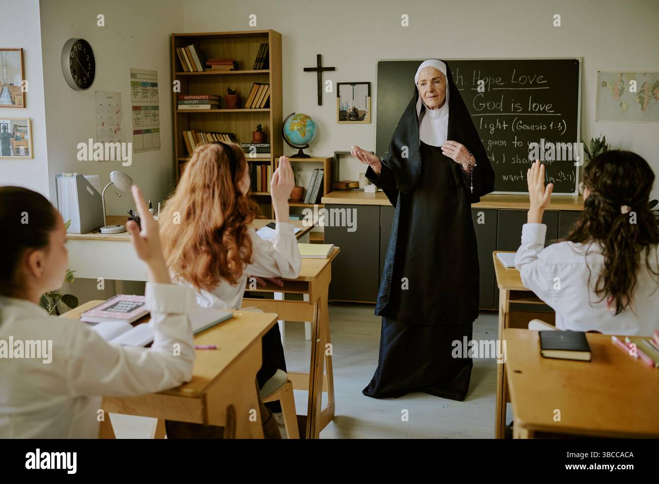 Religious sister engaging students in classroom, standing near ...