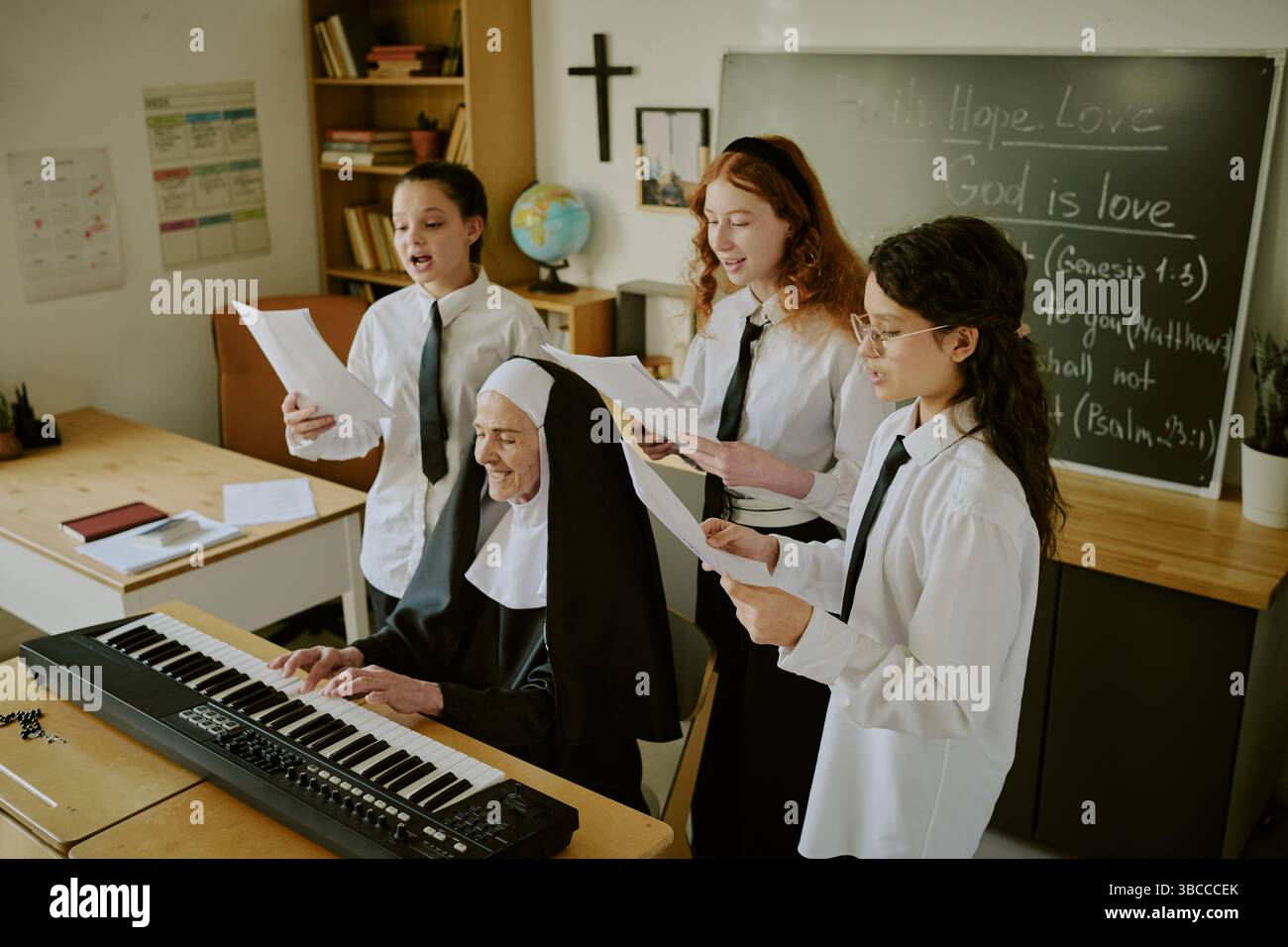 Elderly nun playing electric piano while students sing in classroom ...