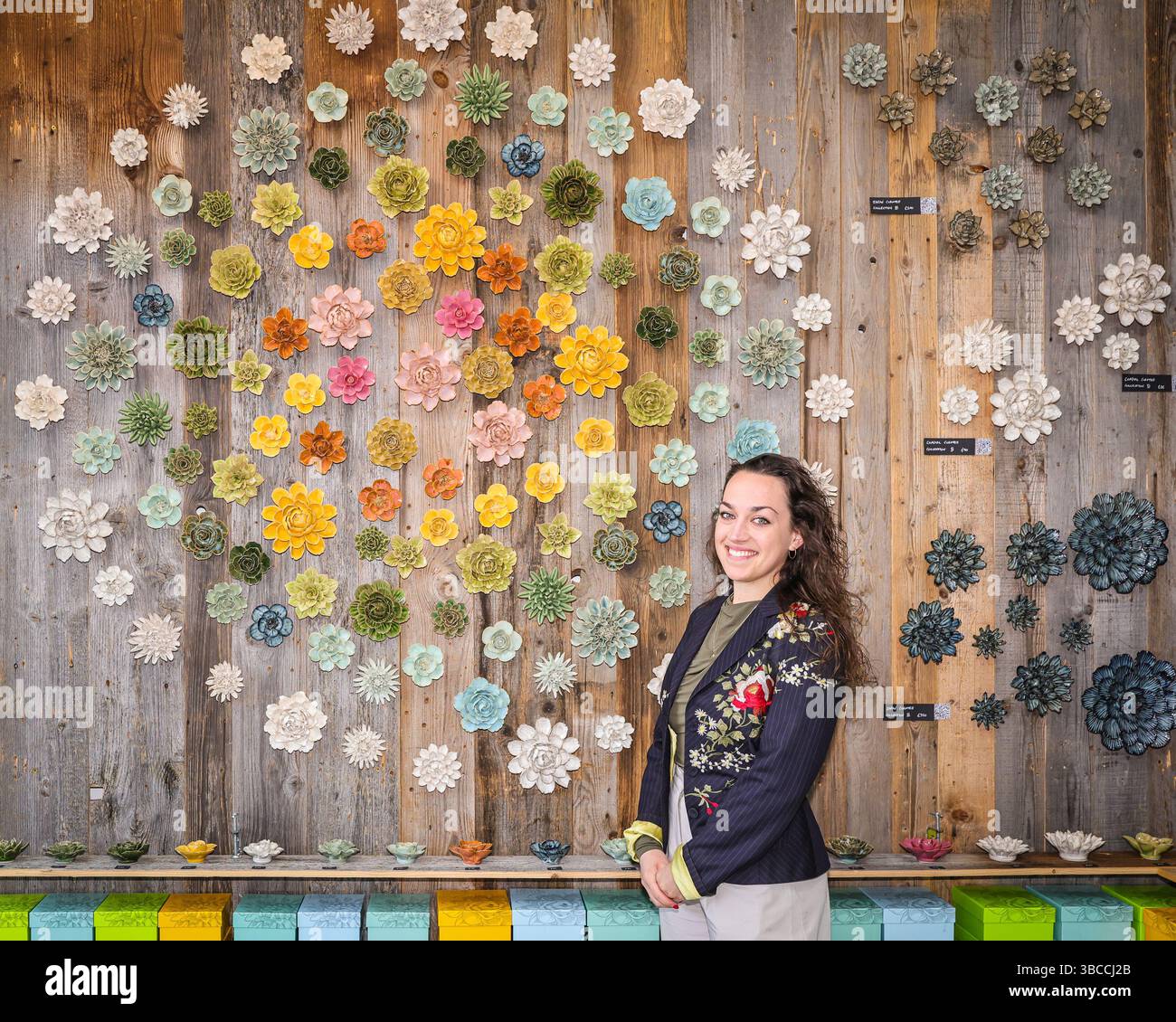 London, UK. 19th May, 2025. Staff with a colourful ceramic flower ...