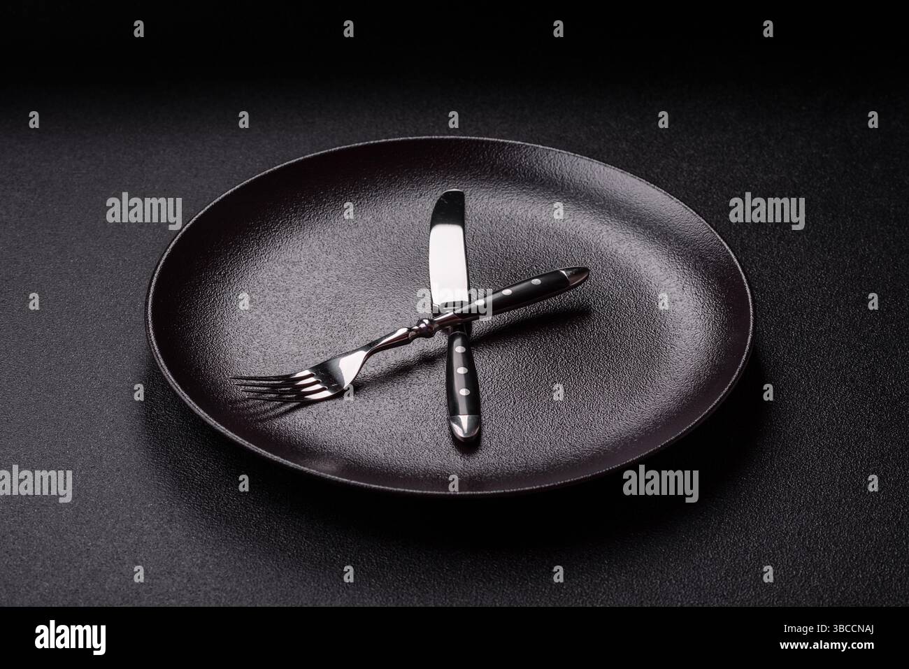 Empty plate with devices in the form of clock hands as a conceptual ...