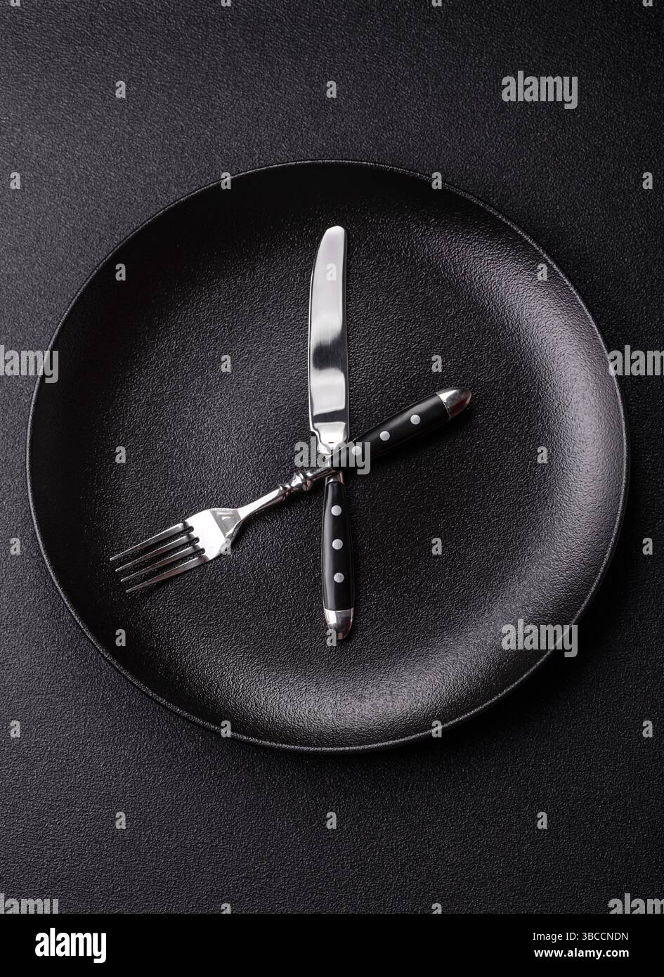 Empty plate with devices in the form of clock hands as a conceptual ...