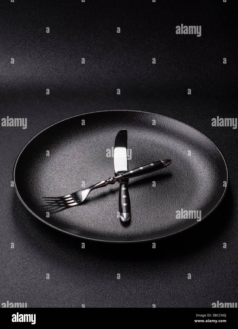 Empty plate with devices in the form of clock hands as a conceptual ...