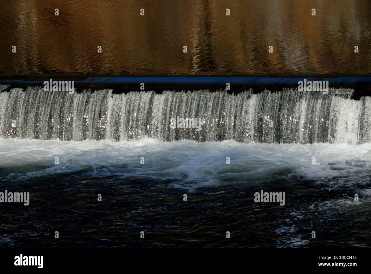 Small waterfall over a weir with light reflections, Germany Stock Photo ...