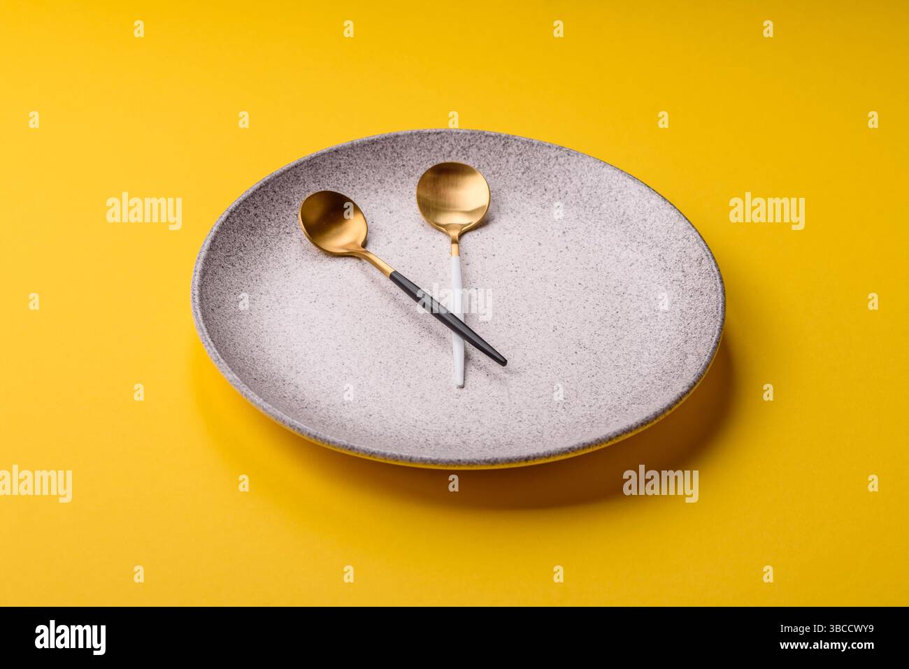 Empty plate with devices in the form of clock hands as a conceptual ...