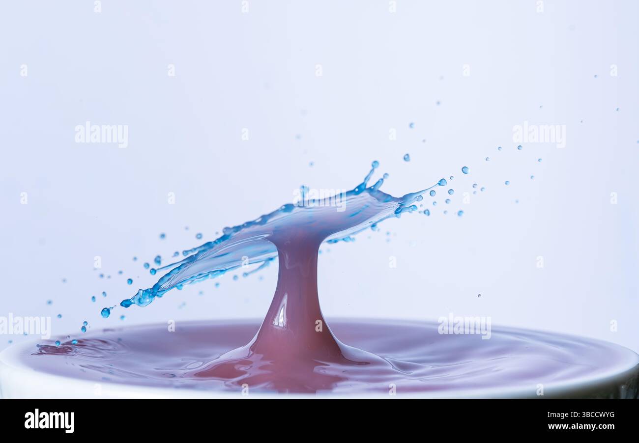 A high-speed photograph captures a water drop collision in mid-air ...