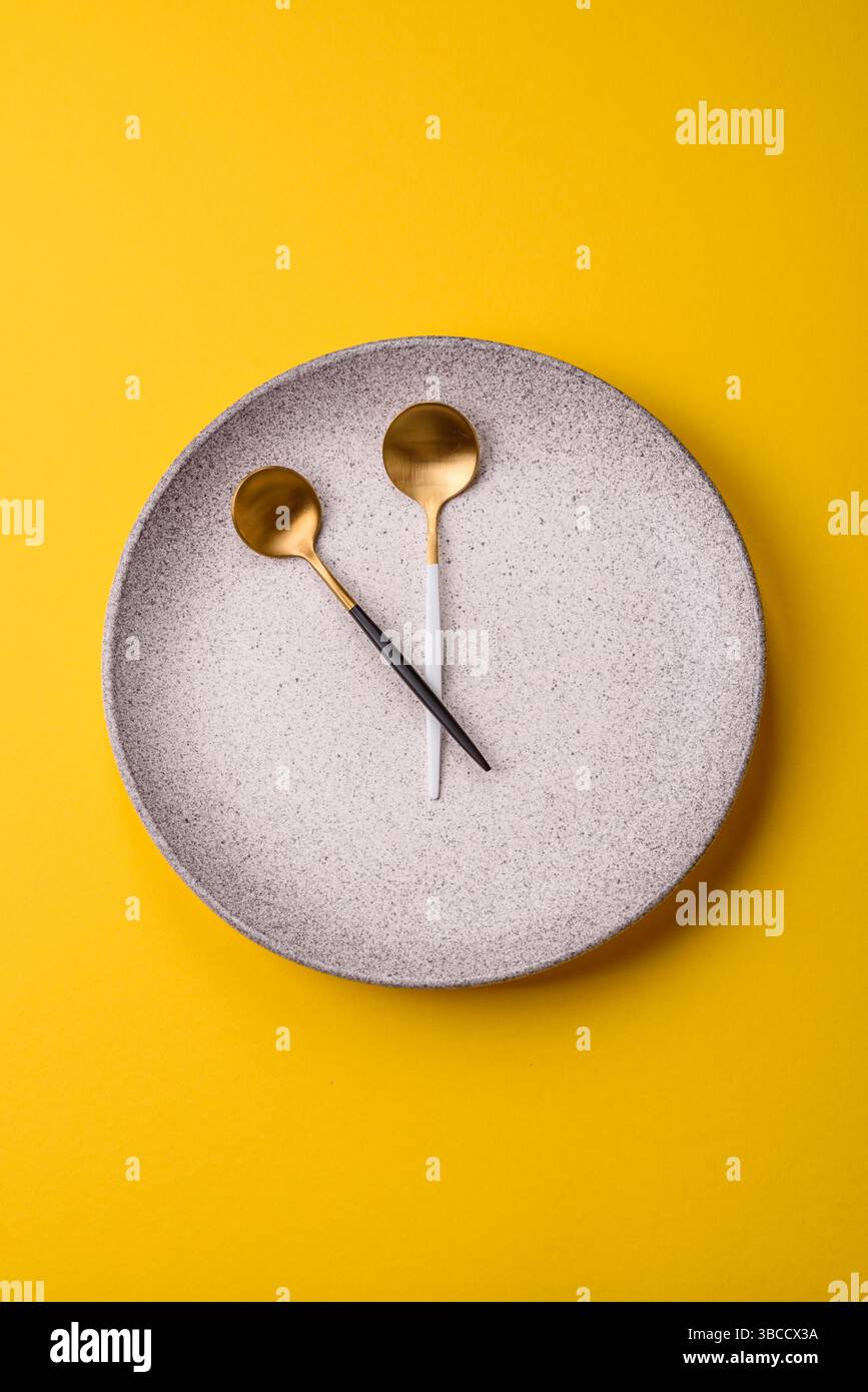 Empty plate with devices in the form of clock hands as a conceptual ...