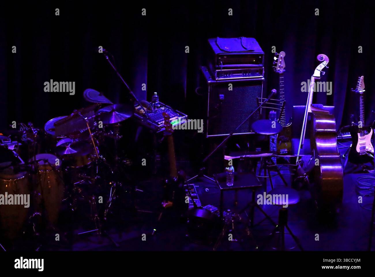 Various musical instruments placed on the stage of a dimly lit live ...