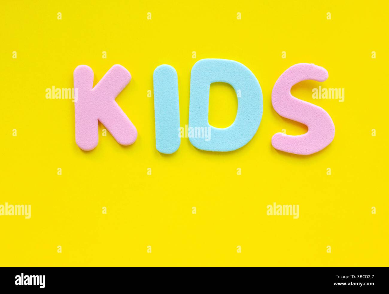 Word Kids made of colorful letters on yellow background, flat lay with ...