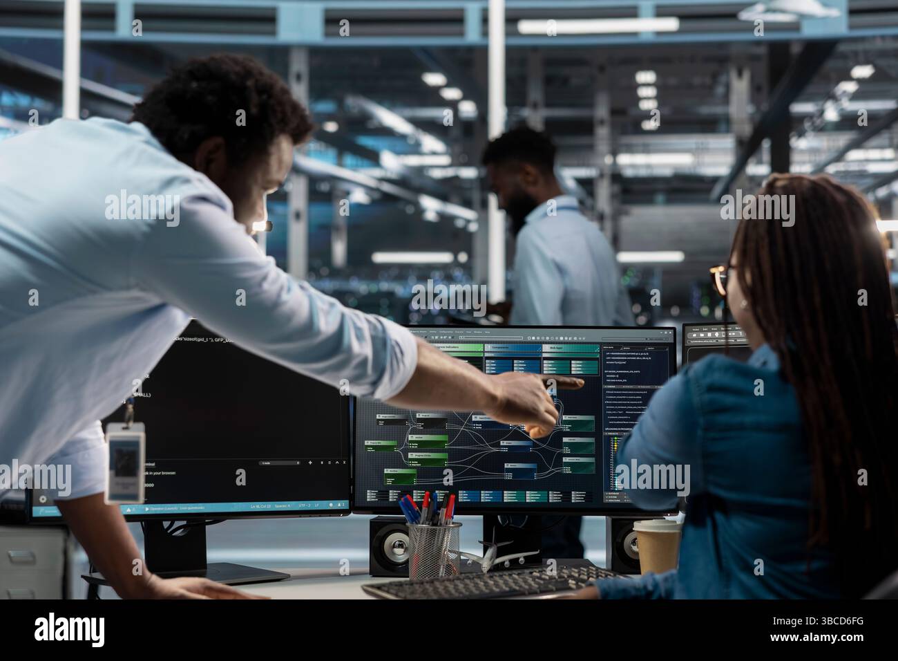 Data center supervisor overseeing admin using PC to visualize ...