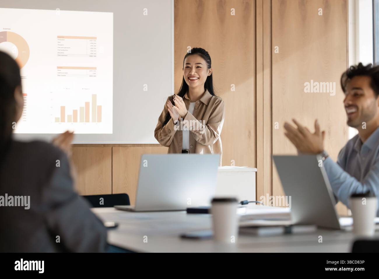 Employees clapping in appreciation to young Asian business woman coach ...