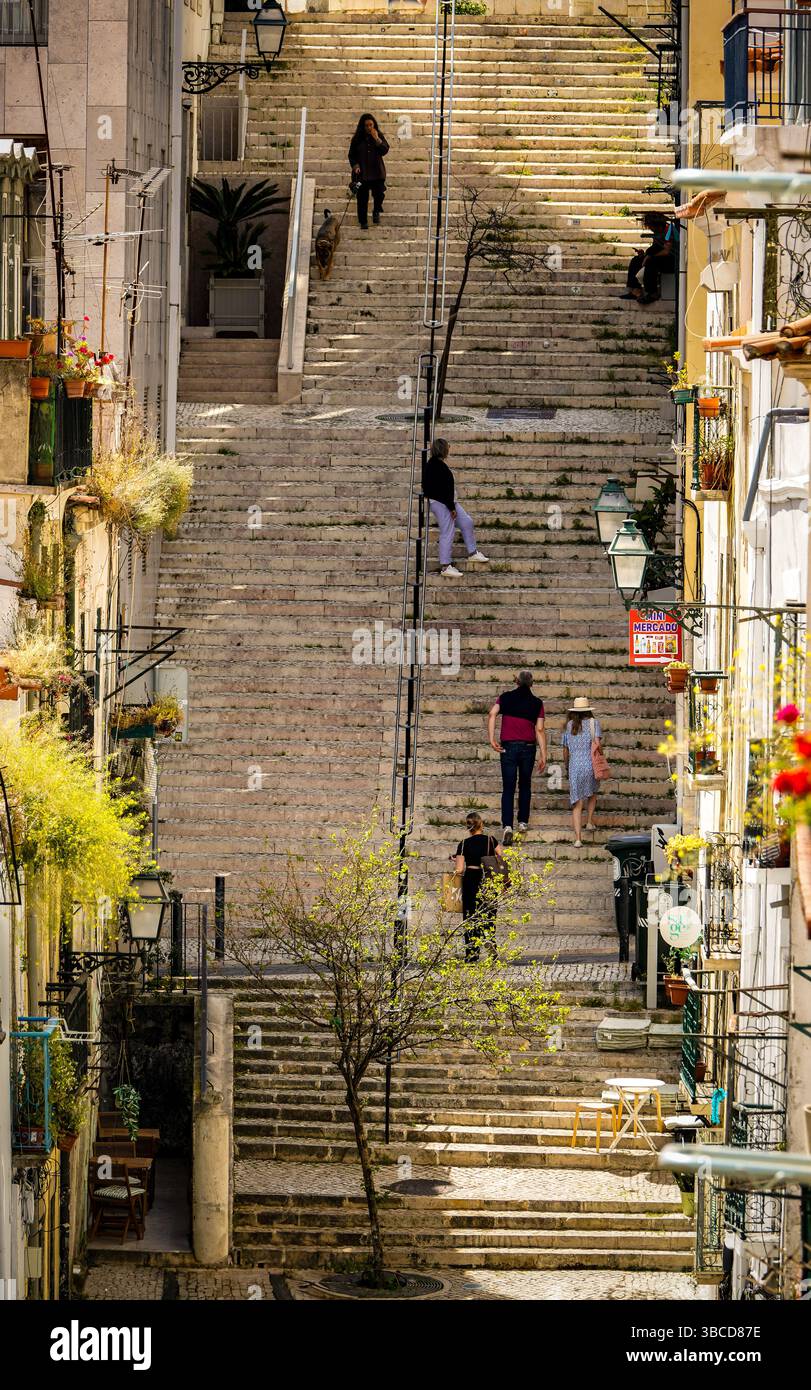 People climbing steep stone steps between colorful traditional ...