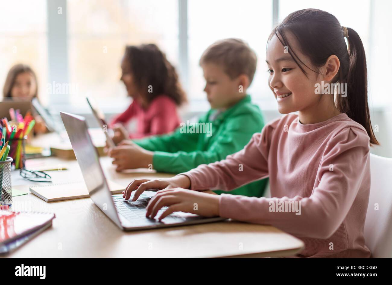 Diverse Children Learning Using Laptop In Modern Classroom At School ...