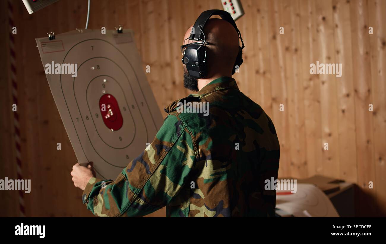 Cheerful army unit in firing range shooting targets with pistol pleased ...