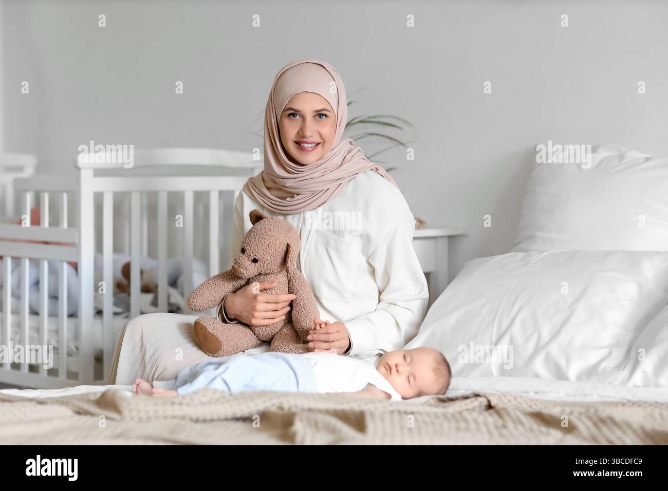 Happy Muslim mother in hijab with teddy bear and cute little baby ...