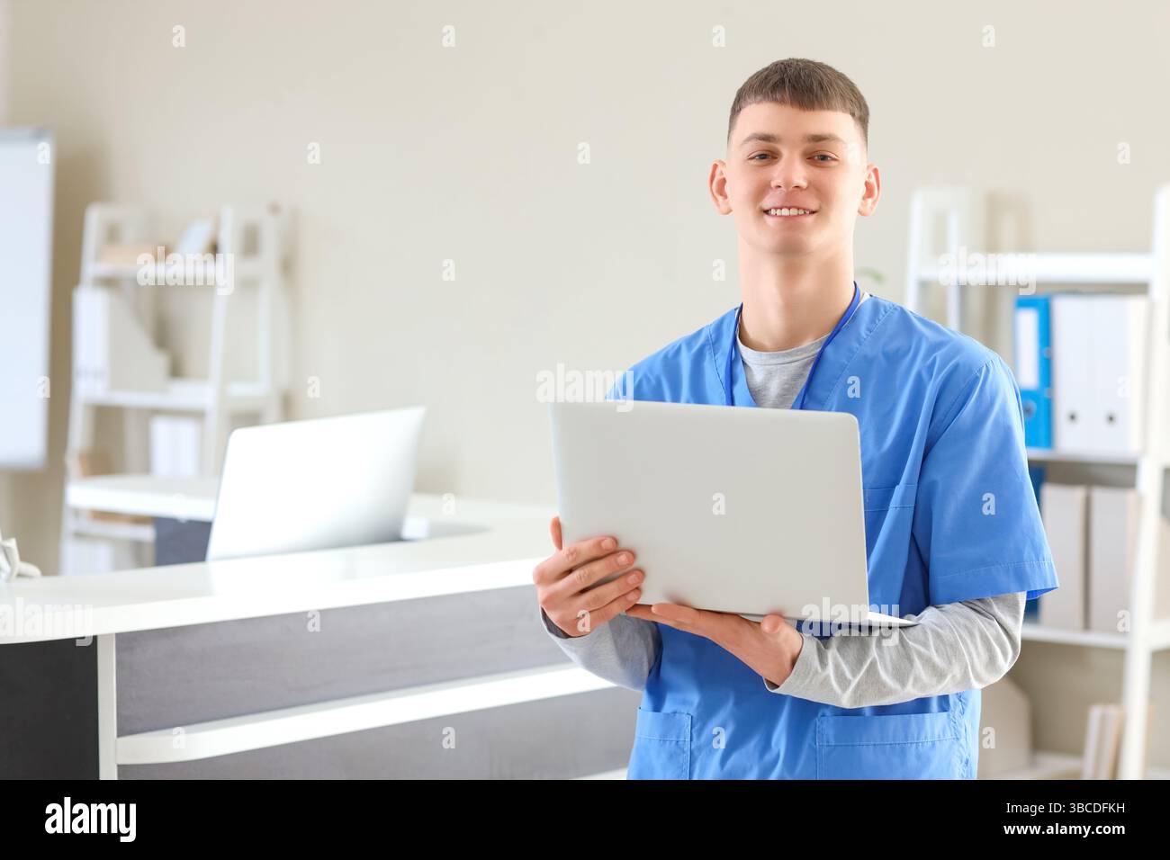 Male medical intern with laptop in clinic Stock Photo - Alamy