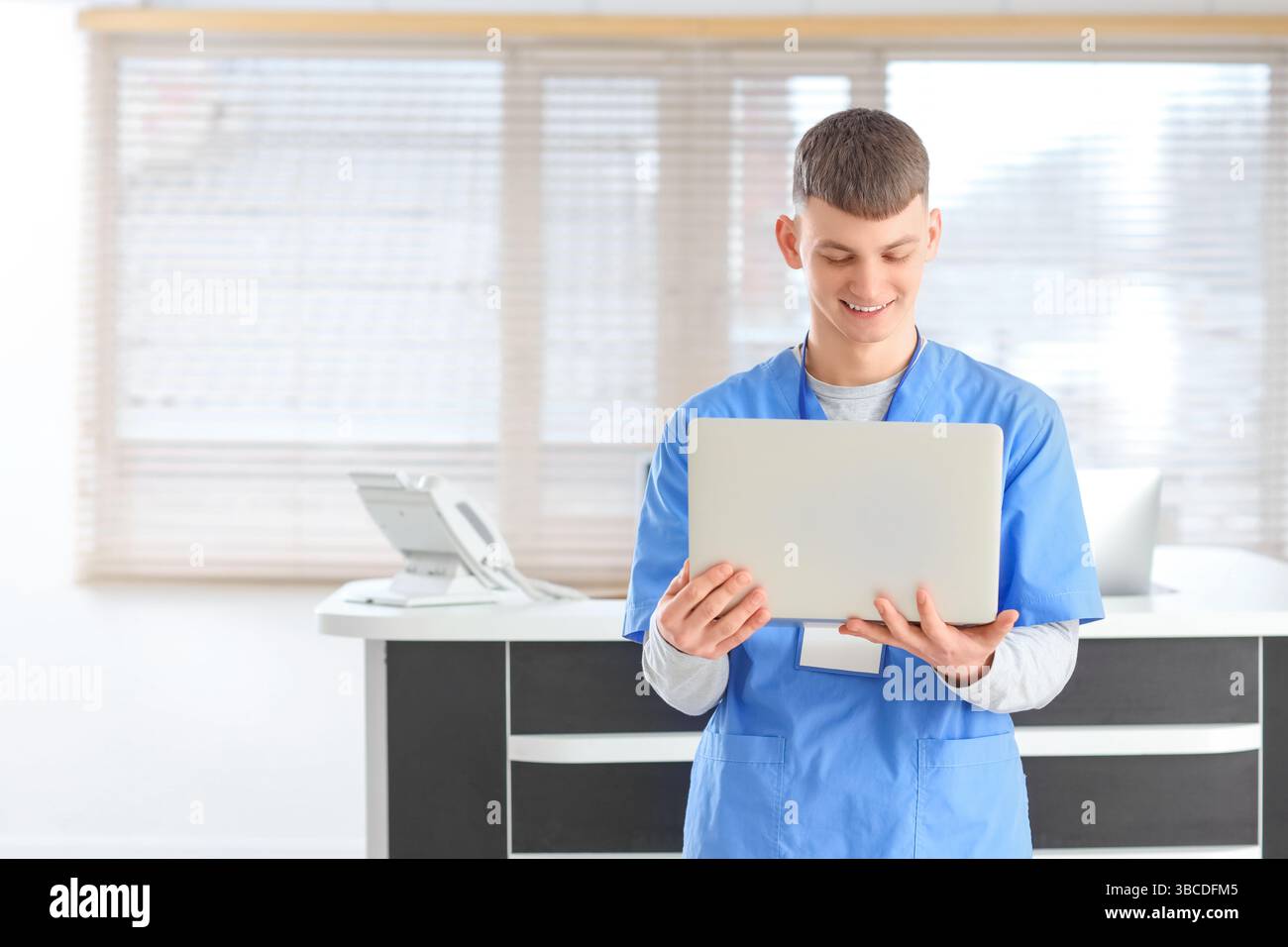 Male medical intern with laptop in clinic Stock Photo - Alamy