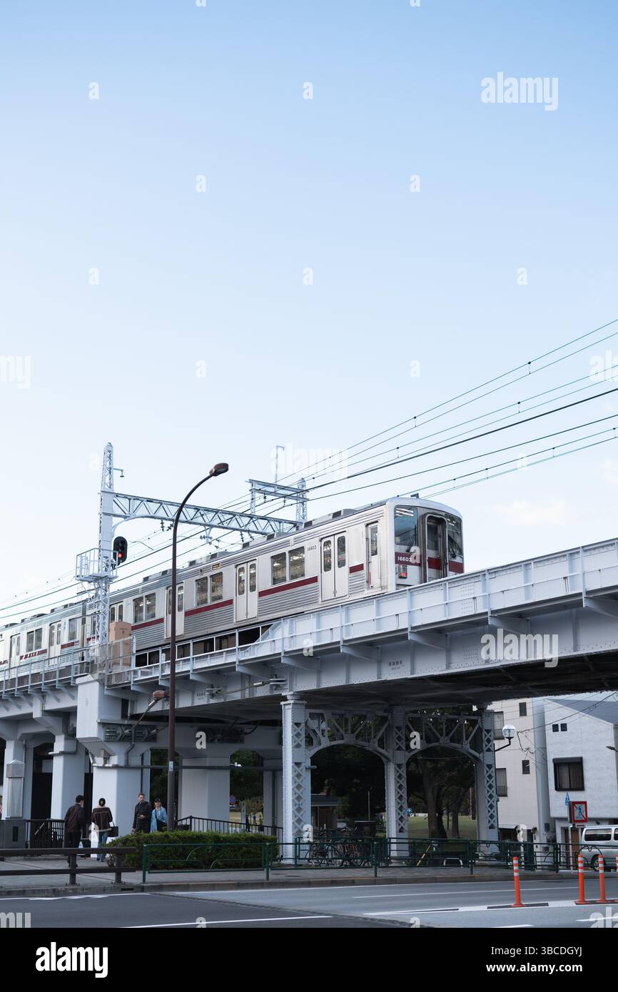 Commuter train passing over bridge in urban japan Stock Photo - Alamy