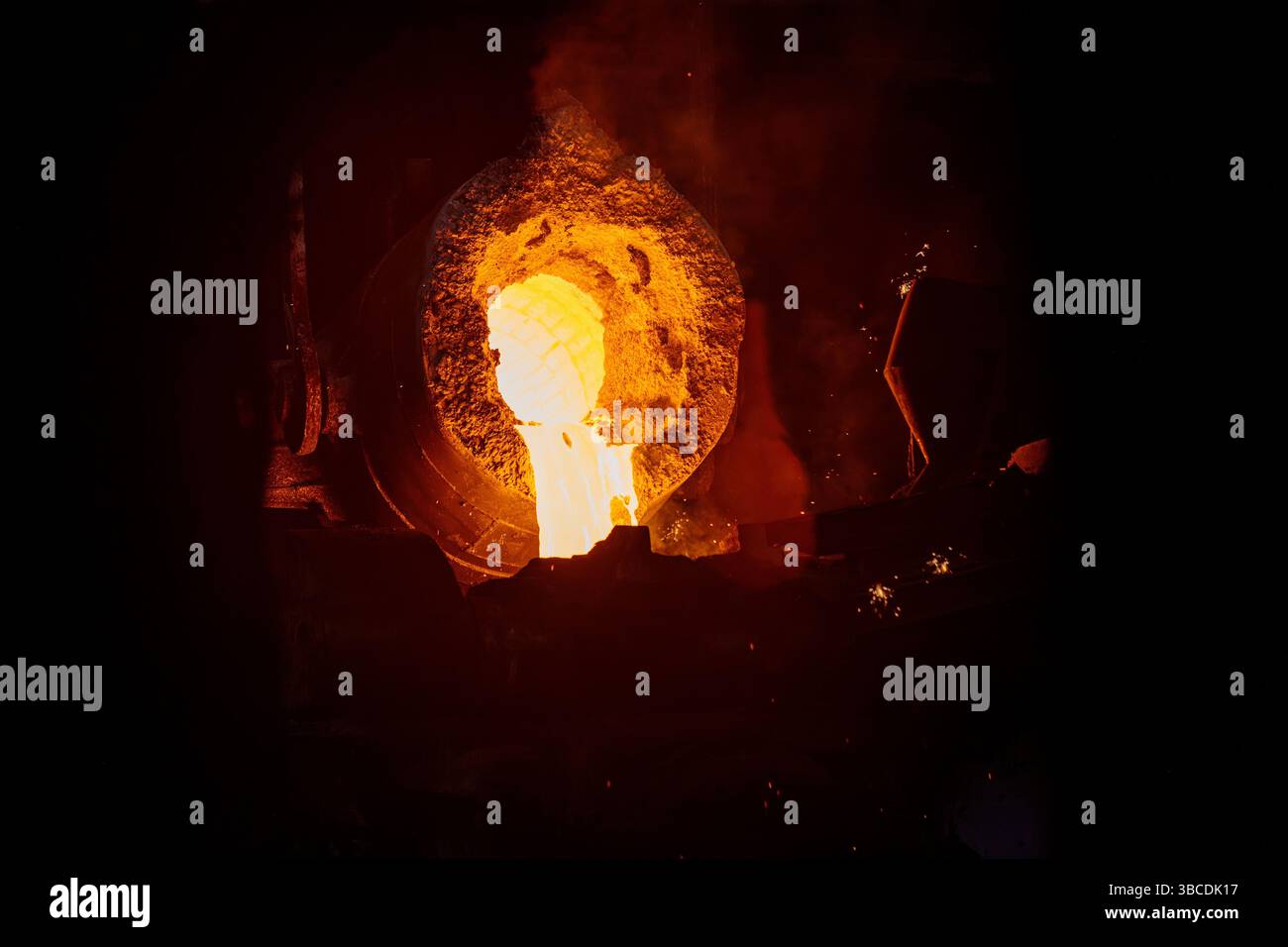 Metal casting process in metallurgical plant, molten metal is pouring ...