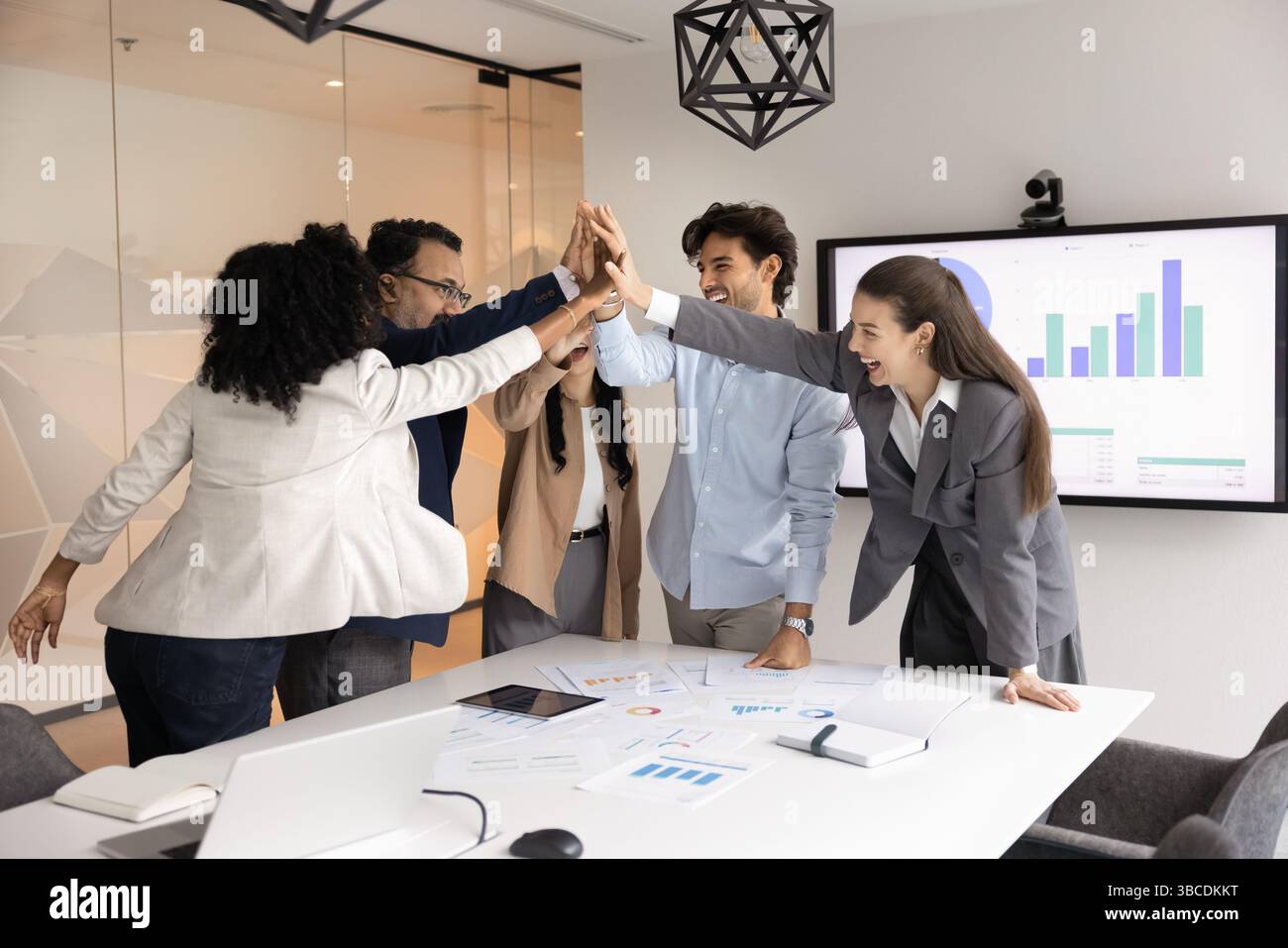 Professionals giving high five gathered together around conference ...