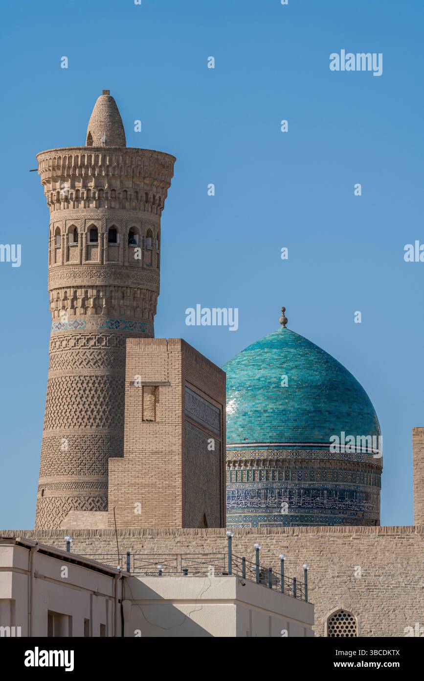 A tall cylindrical minaret and domed roof stand at Kalyan Minaret in ...