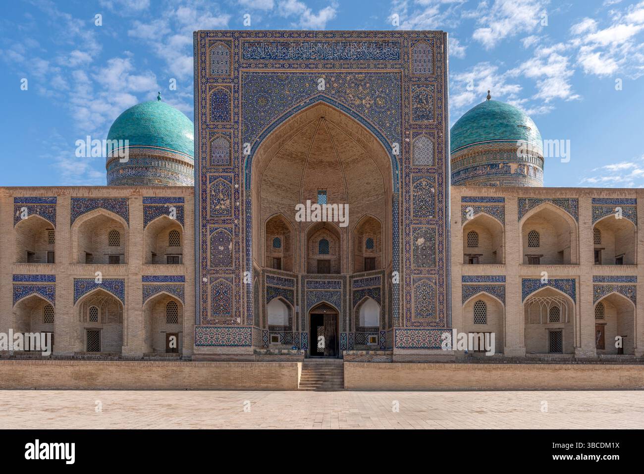 A monumental portal with blue tiles and domes marks Mir-i-Arab Madrasa ...