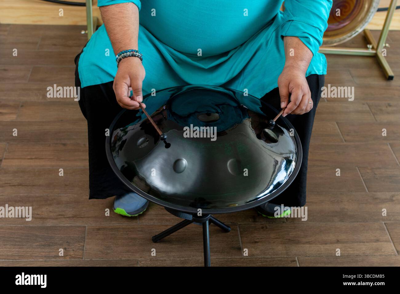 Musician playing handpan drum in music studio for sound healing therapy ...