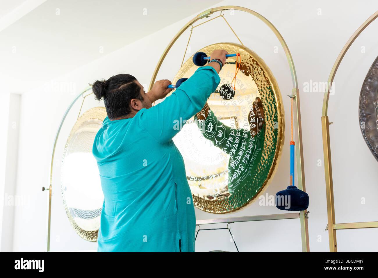 Music therapist playing gong during sound healing session Stock Photo ...