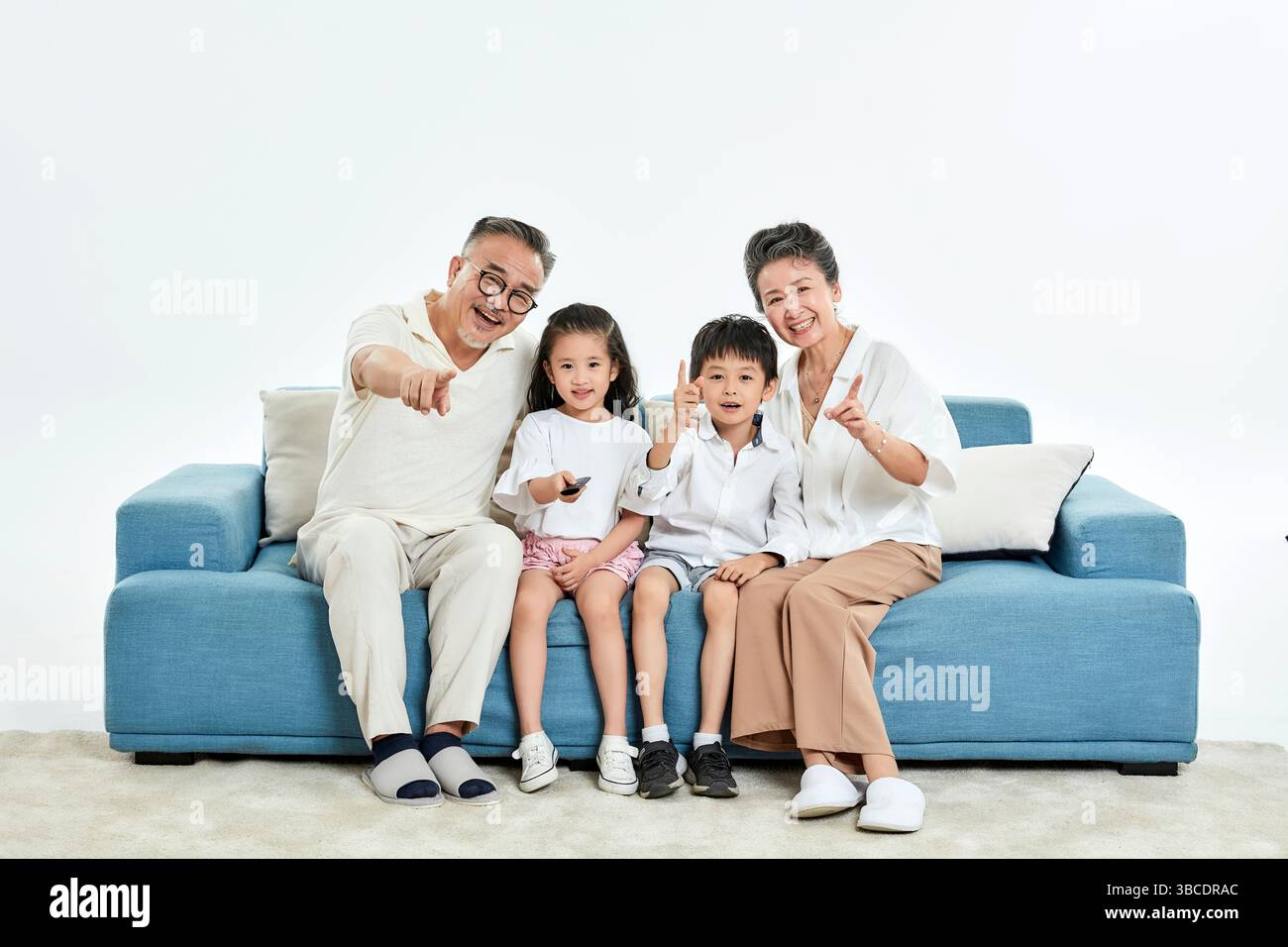 four generations (grandparents and grandchildren) watching TV on the sofa Stock Photo - Alamy