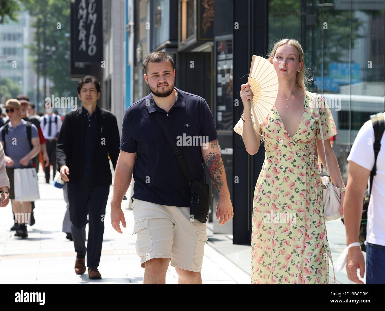 People walk on a street while the temperature rising at Ginza district ...