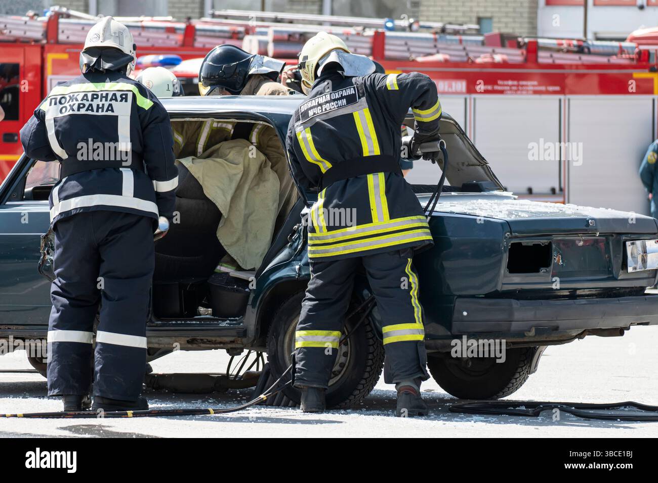 Firefighters breaking a car windscreen to help a car crash victim ...