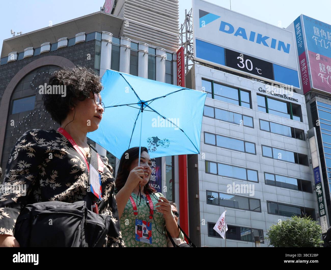 People walk on a street while the temperature rising at Ginza district in Chuo Ward, Tokyo on ...