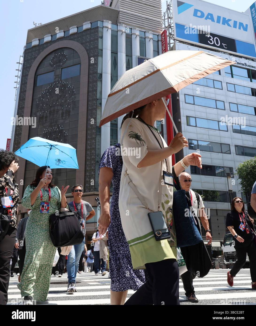 People walk on a street while the temperature rising at Ginza district in Chuo Ward, Tokyo on ...