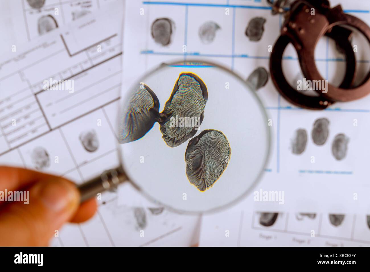 Police examines fingerprints through magnifying glass next to police ...