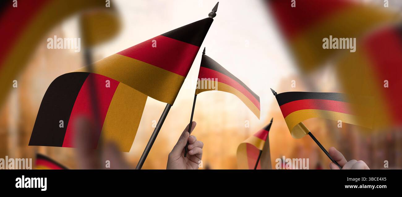 Germany flags in their hands on a blurred urban background Stock Photo ...