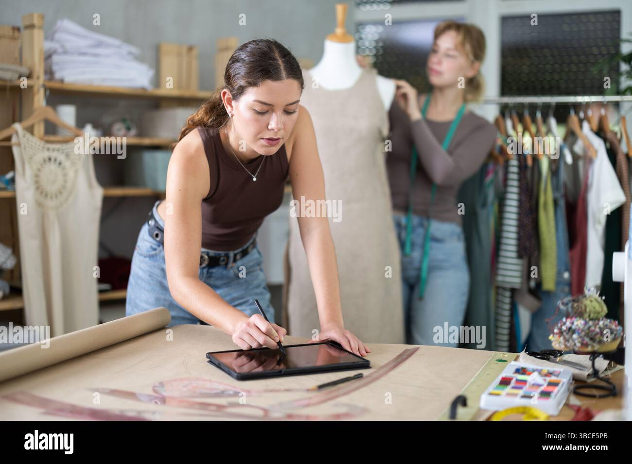 Female fashion designers create design clothes in the workshop Stock ...