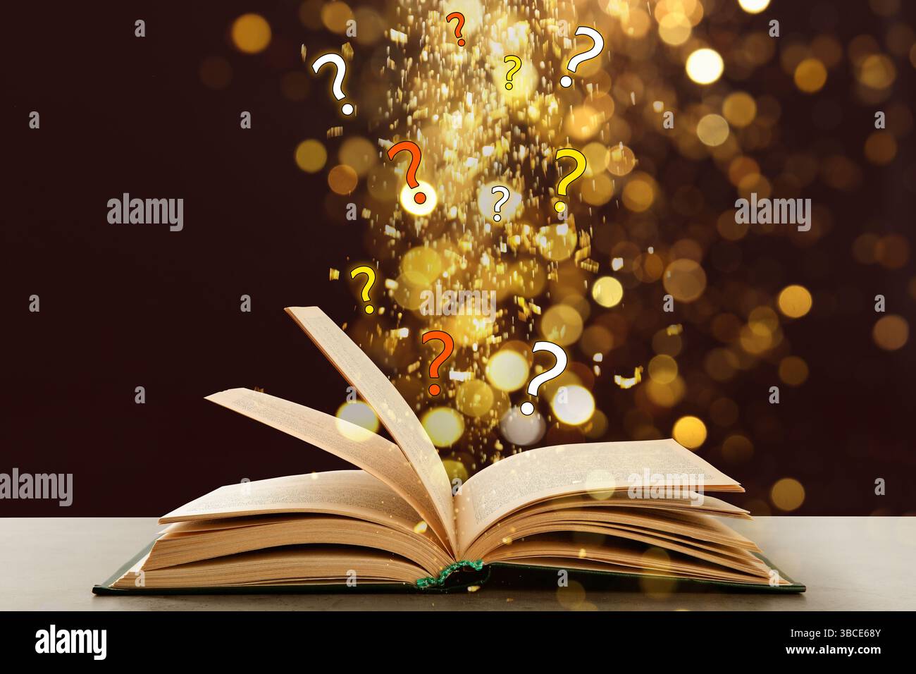 Question marks and magic lights flying out of open book on table ...