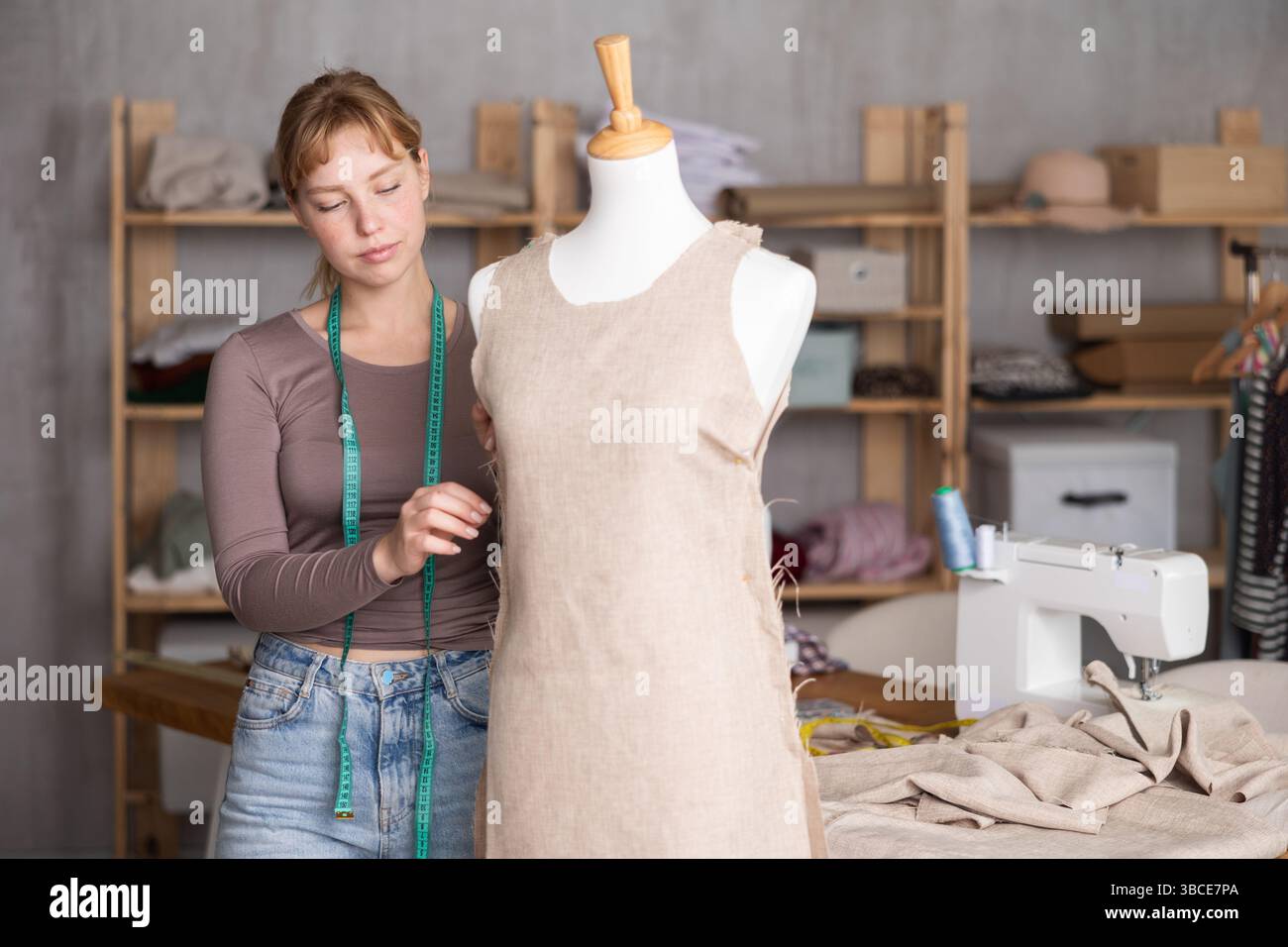 Dressmaker woman checking a sewn dress Stock Photo - Alamy