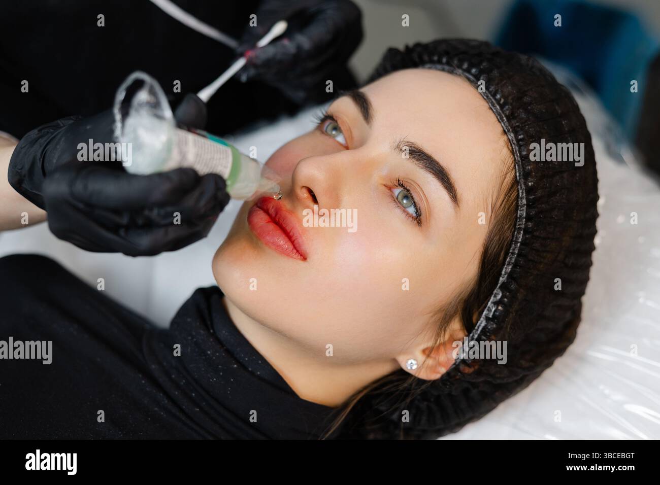 Beautician in black gloves performing hi-res stock photography and ...