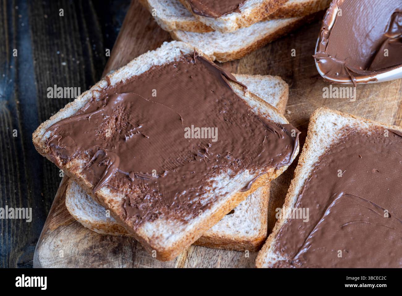 Chocolate butter spread on bread while cooking breakfast, making ...